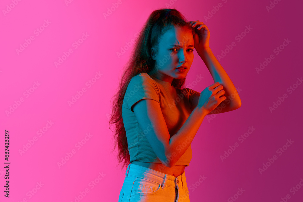 Young girl standing with scared face against pink studio background in ...