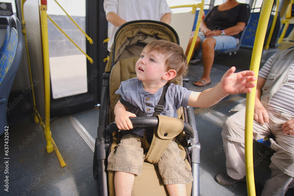 The baby boy is leaving the bus with his mother, ready to exit and ...