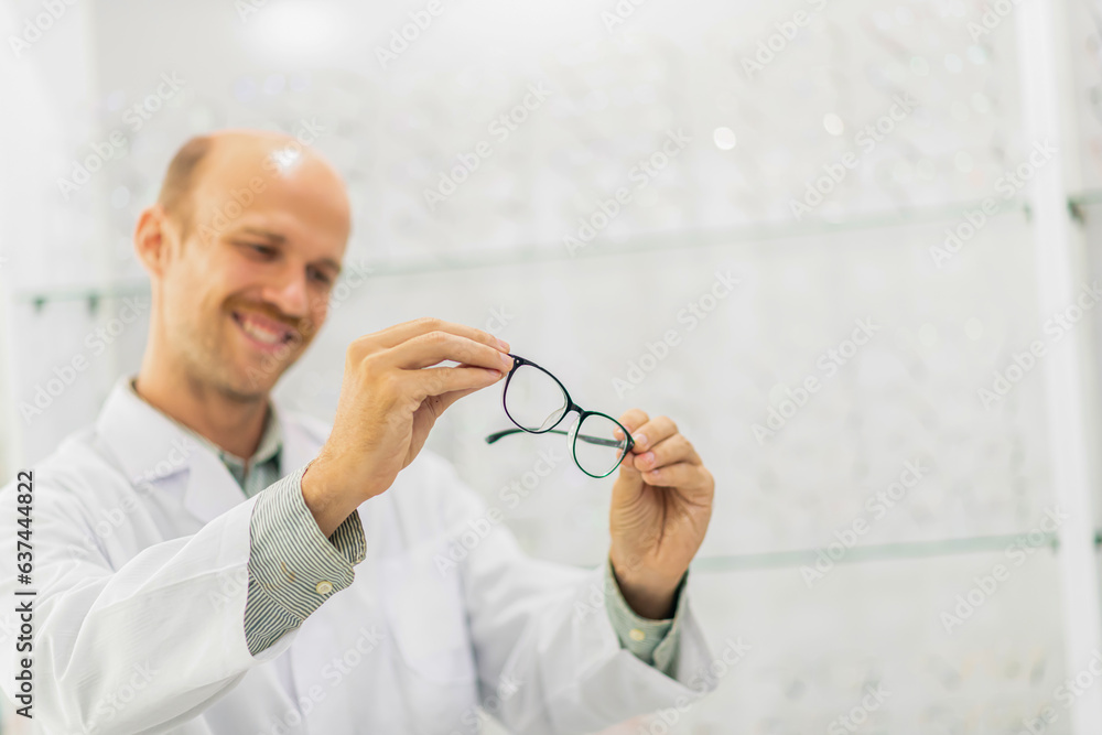 Male optician and optometrist, background of shop window with different ...