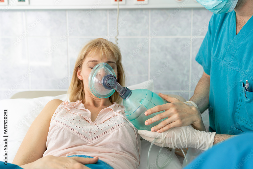 Scared pregnant woman receiving oxygen mask bottle by male medical ...