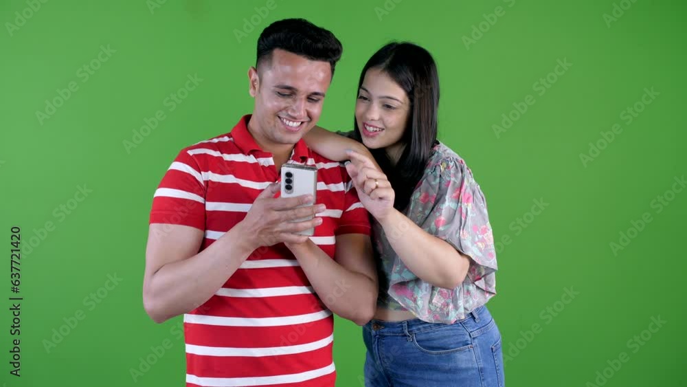 Indian young couple scrolling on their smartphone in their leisure time ...