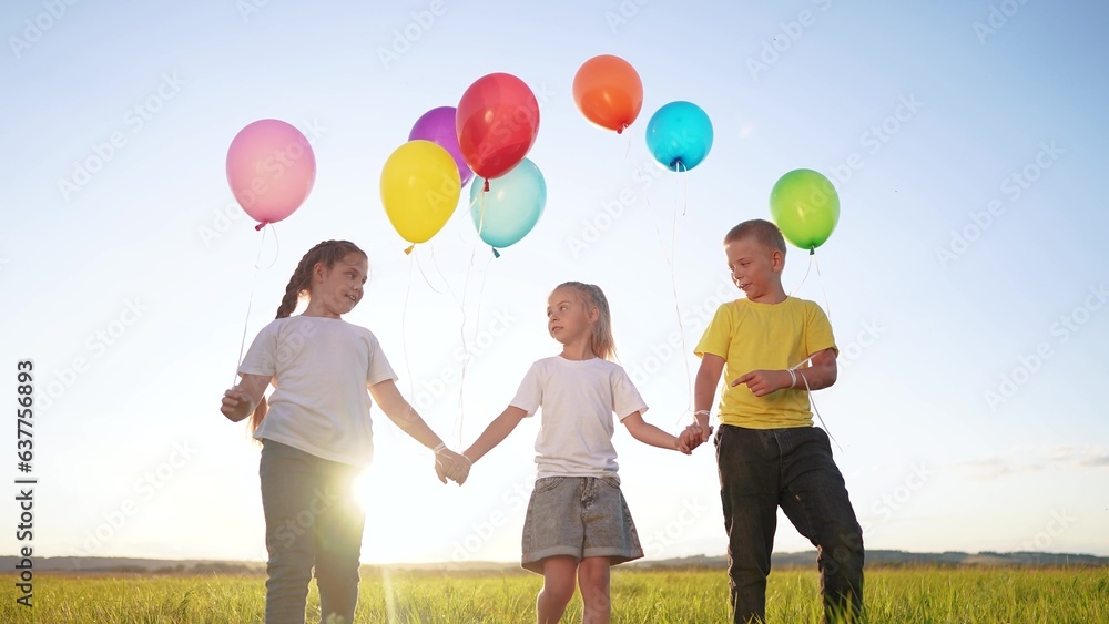 children in balloons in the park. children walk in nature in park with ...