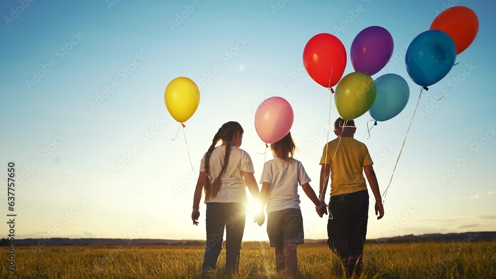 children in balloons in the park. children walk in nature in park with ...