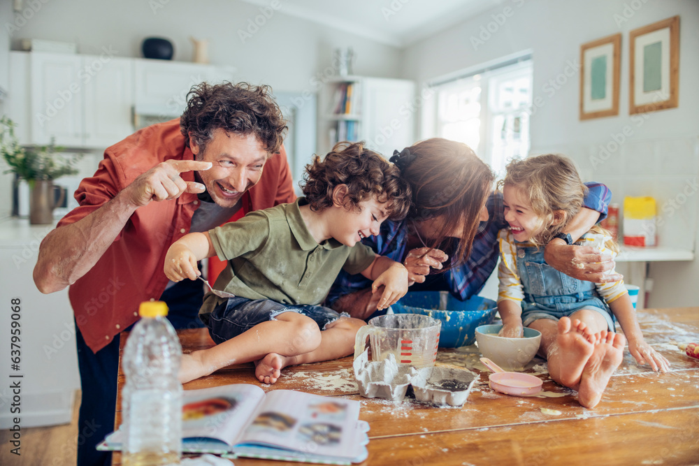 Young caucasian family being messy and having fun baking together in ...