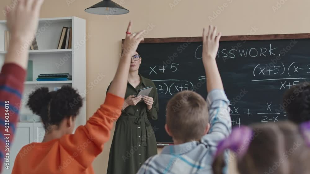 Multiethnic preteen students raising their hands to solve Math equation ...