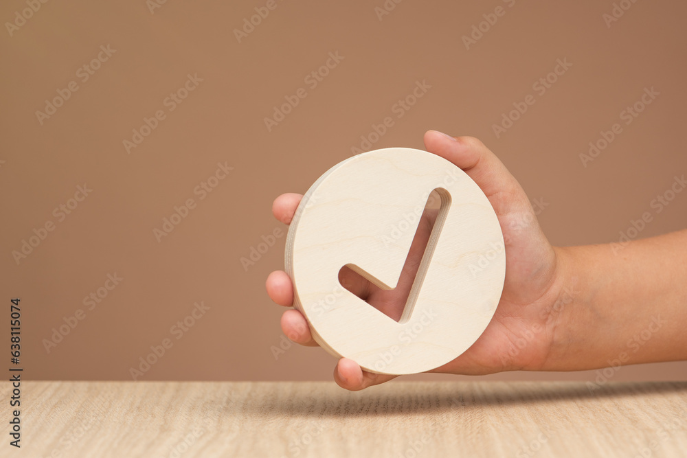 Hand holding check mark icon, banner with wooden check mark icon in ...