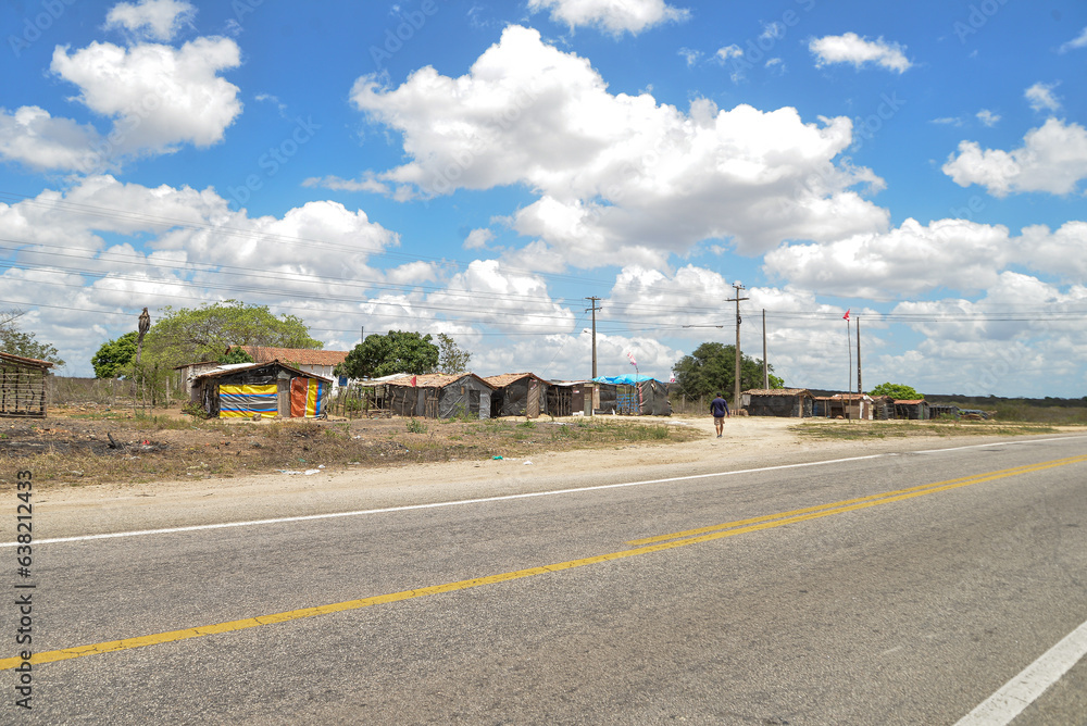 man walking towards small houses in rural area by the roadside in ...