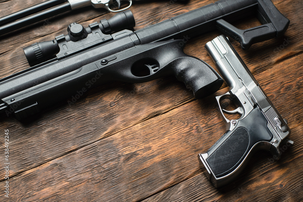 Various toy guns on the wooden table background with copy space. Secret ...