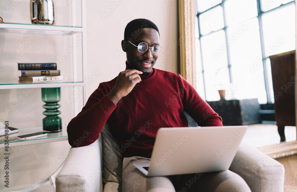 Delighted man looking at screen of laptop while working Stock Photo ...