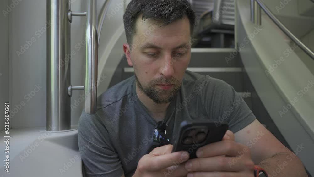 Young man travels on double decker train and sits on flyer using his ...