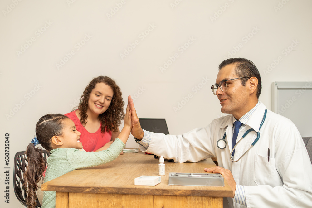 doctor cheering up making high five with a little child girl at doctor ...
