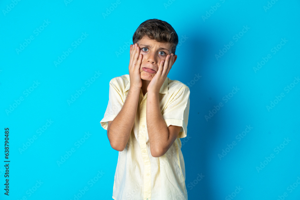 Beautiful kid boy wearing casual shirt Tired hands covering face ...