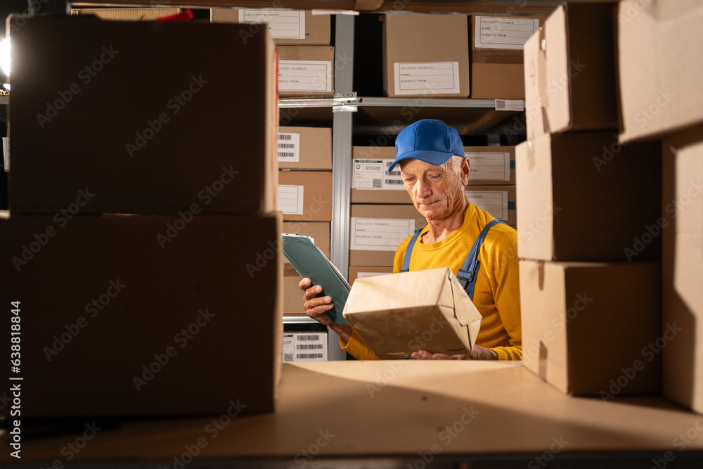 Elderly delivery man or warehouse worker with parcel box and clipboard ...