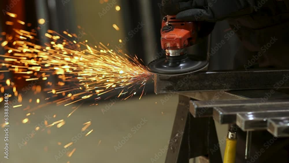 Worker sanding welding seam iron steel pipe profile, using Angle ...