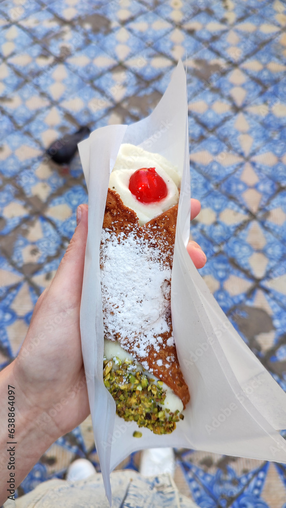Sicilian cannolo in the hand. Female hand holding a sicilian ...