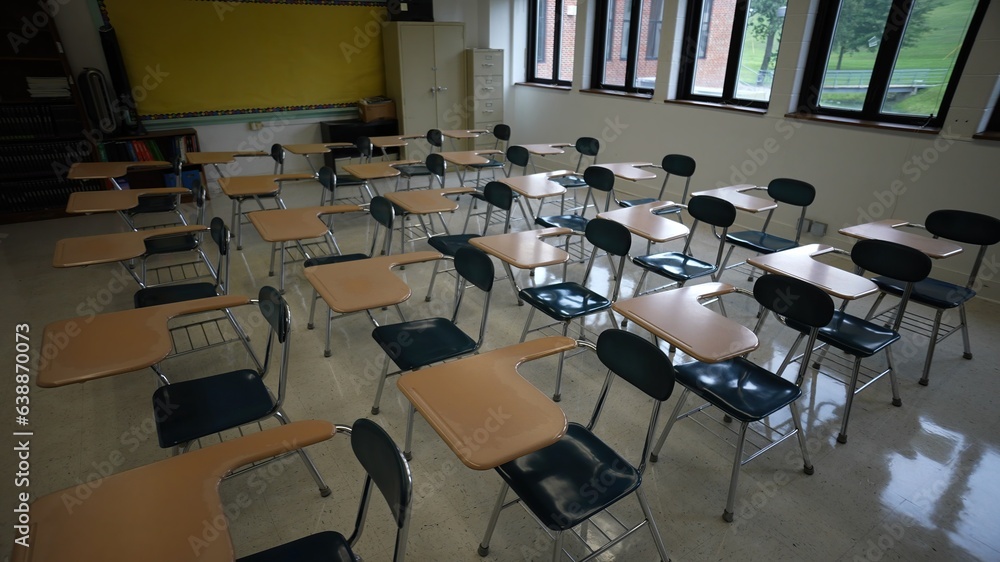 High angle diagonal view of rows of empty desks chairs in a school ...