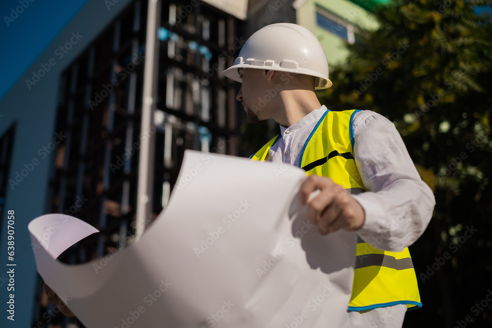 professional male engineer in special uniform and helmet holding ...