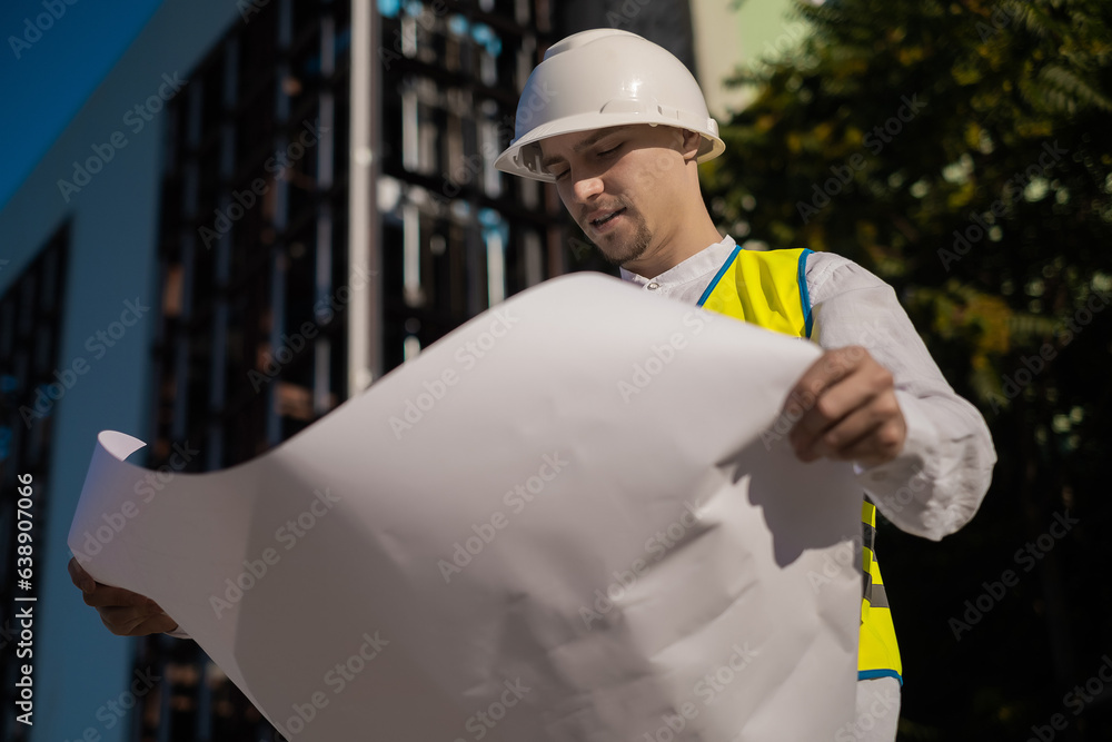 professional male engineer in special uniform and helmet holding ...