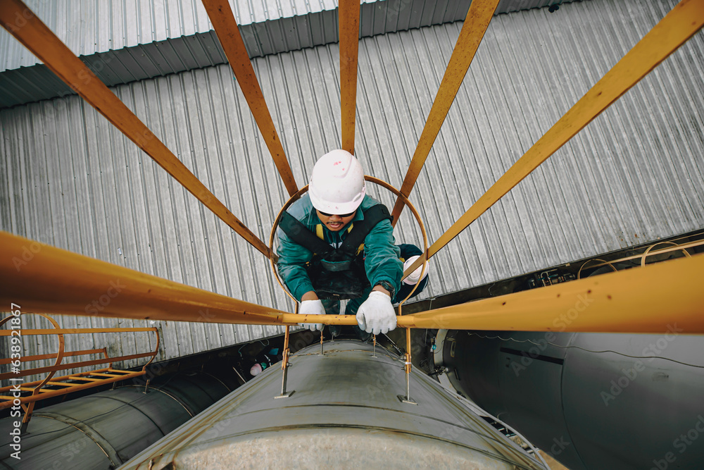 Top view male worker climbs up the ladder inspection stainless tank ...
