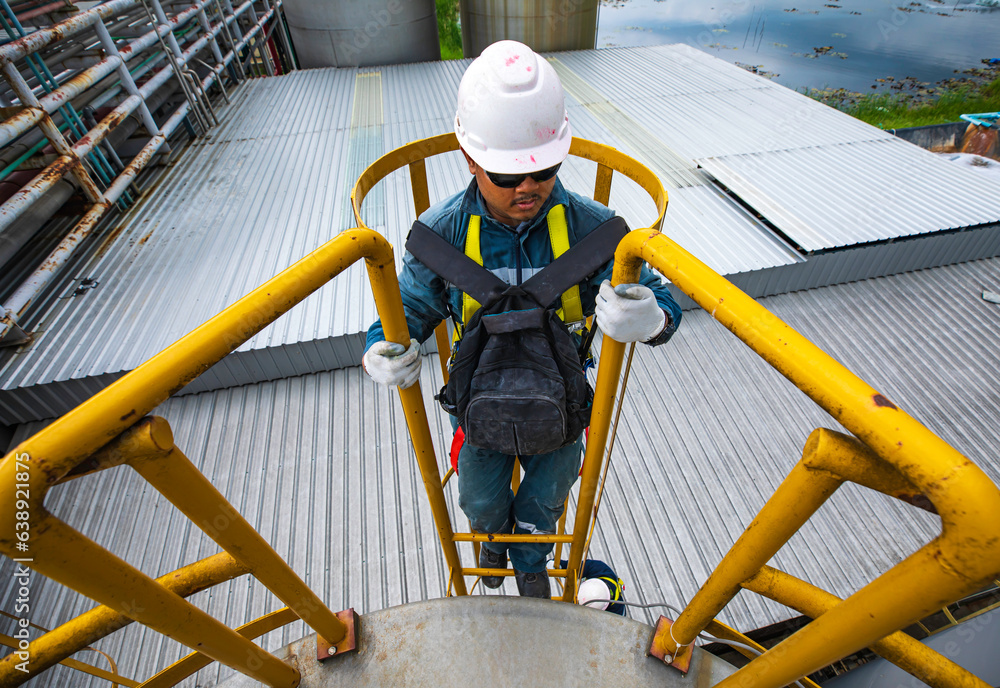 Top view male worker climbs down the ladder inspection stainless tank ...