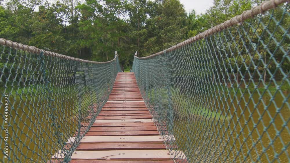 Experience the adventure as you traverse a rope and wooden foot bridge ...