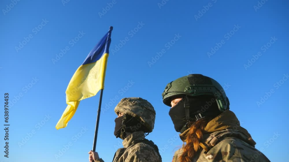 Young soldiers of ukrainian army standing at peak of hill with raised ...