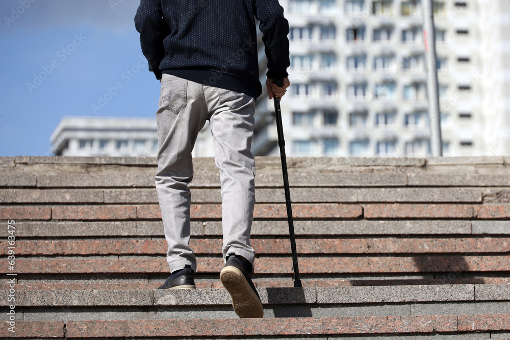 Old man with walking cane climbing stairs on city street. Concept for ...