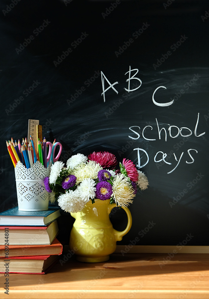 "school days" text on school blackboard. flowers in vase, books ...