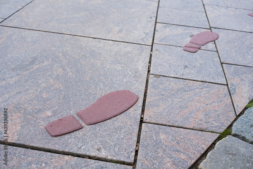 Footprint marks on the ground, painted to mark a tourist route in a ...