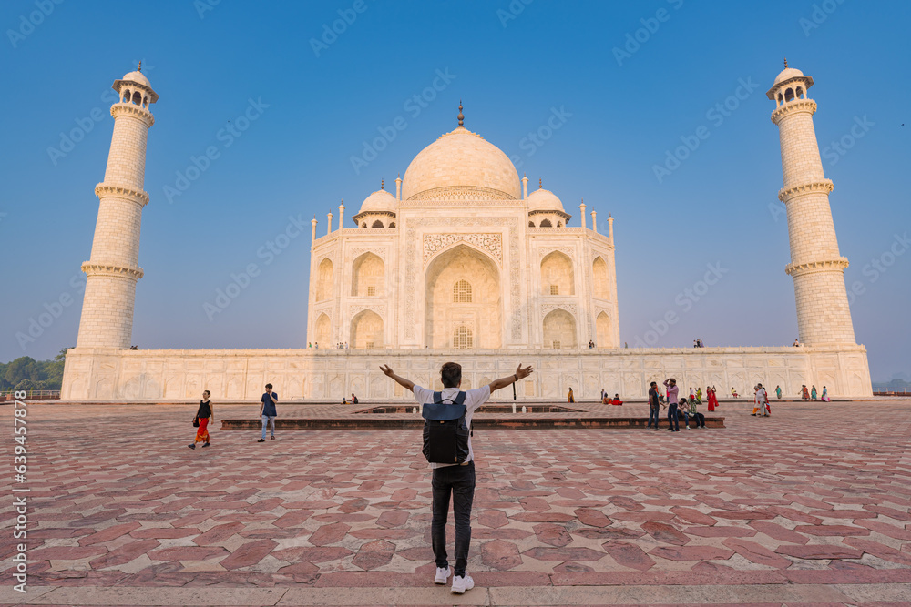 The man with arms around his back standing in front of Taj Mahal indian ...