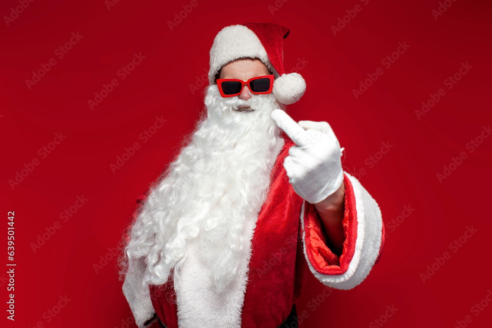 rude santa claus in cap and festive glasses showing middle finger on ...