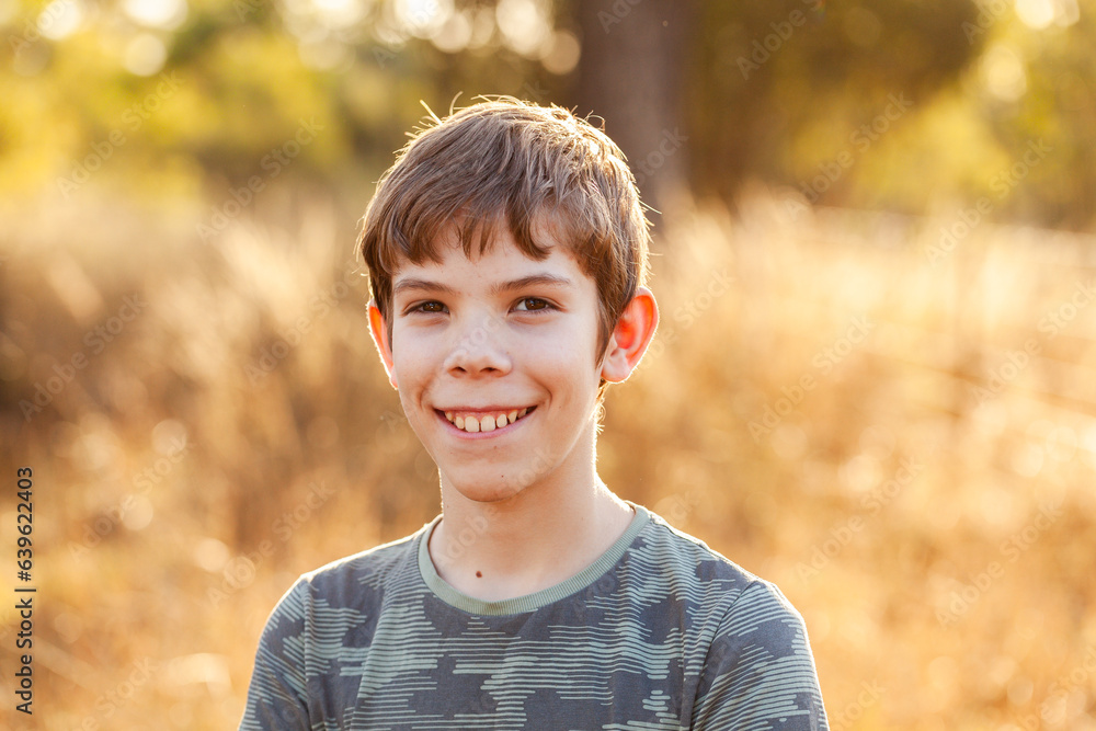 Portrait of a pre-teen boy in rural Australia outside in golden light ...