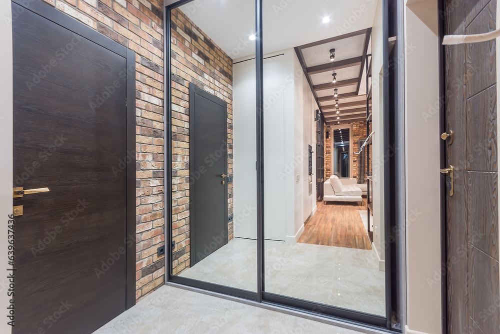 Entrance hall with a stylish design. Dark wood doors, built-in wardrobe ...