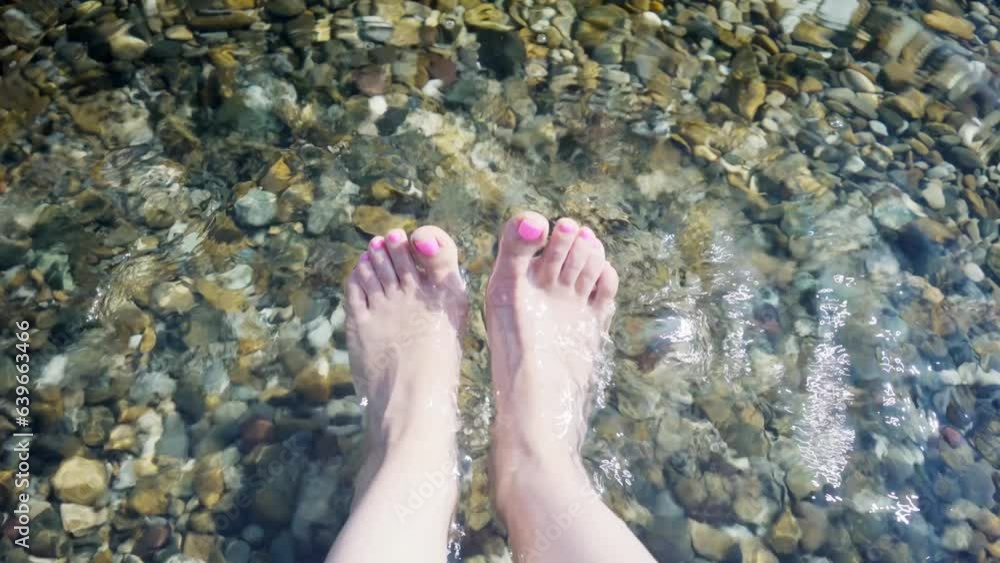 close-up of a women's feet threading in cold water, making a splash, on ...