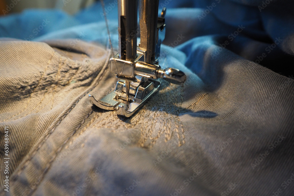 Photo & Art Print the process of repairing clothes with a sewing ...