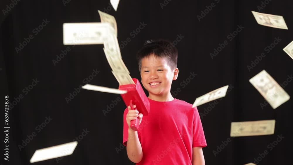 10 year old Asian boy shooting money out of a money gun. Slow Motion ...