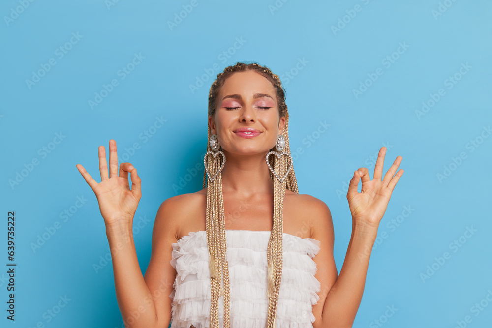 Lovely lady with fair dreads wearing white fluffy top standing in blue ...