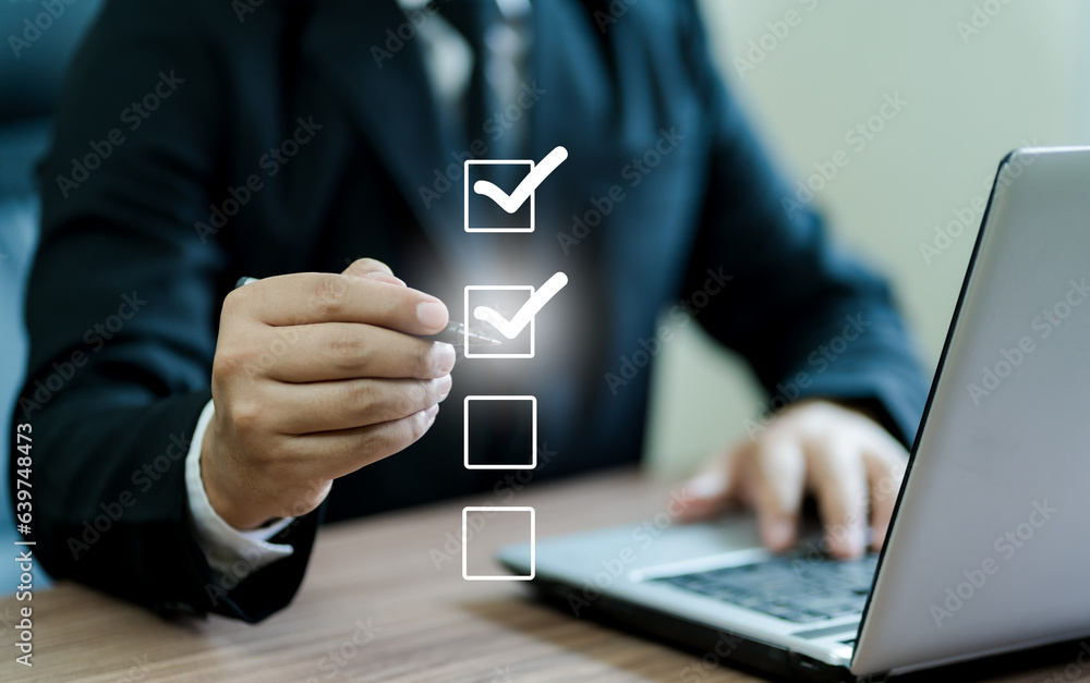 Businessman hand writing a check mark in the box confirming the ...