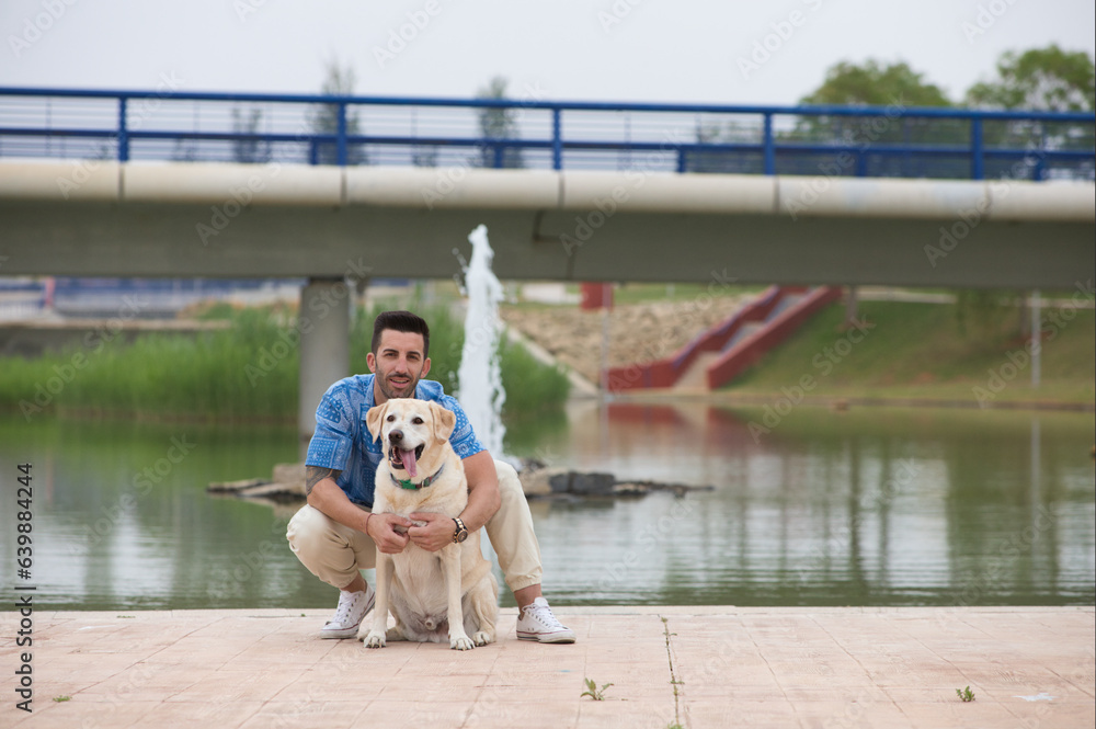 Handsome young man with beard and his Labrador retriever dog, posing ...