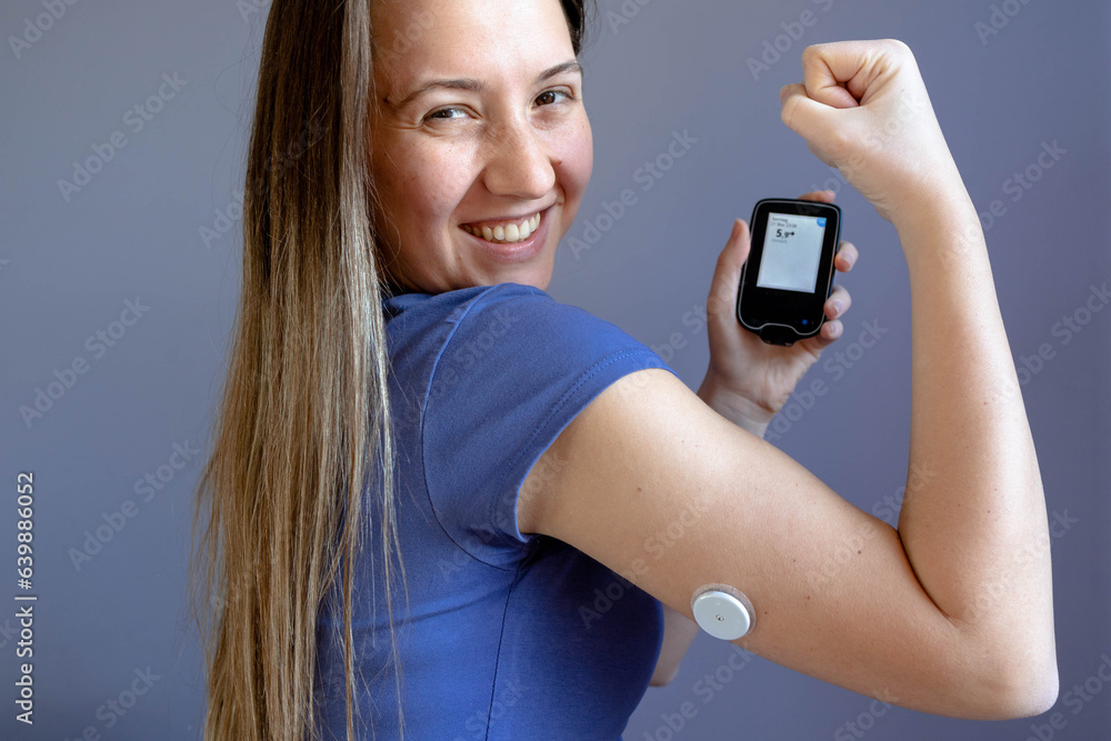Girl showing her flash glucose monitor with normal blood sugar level ...