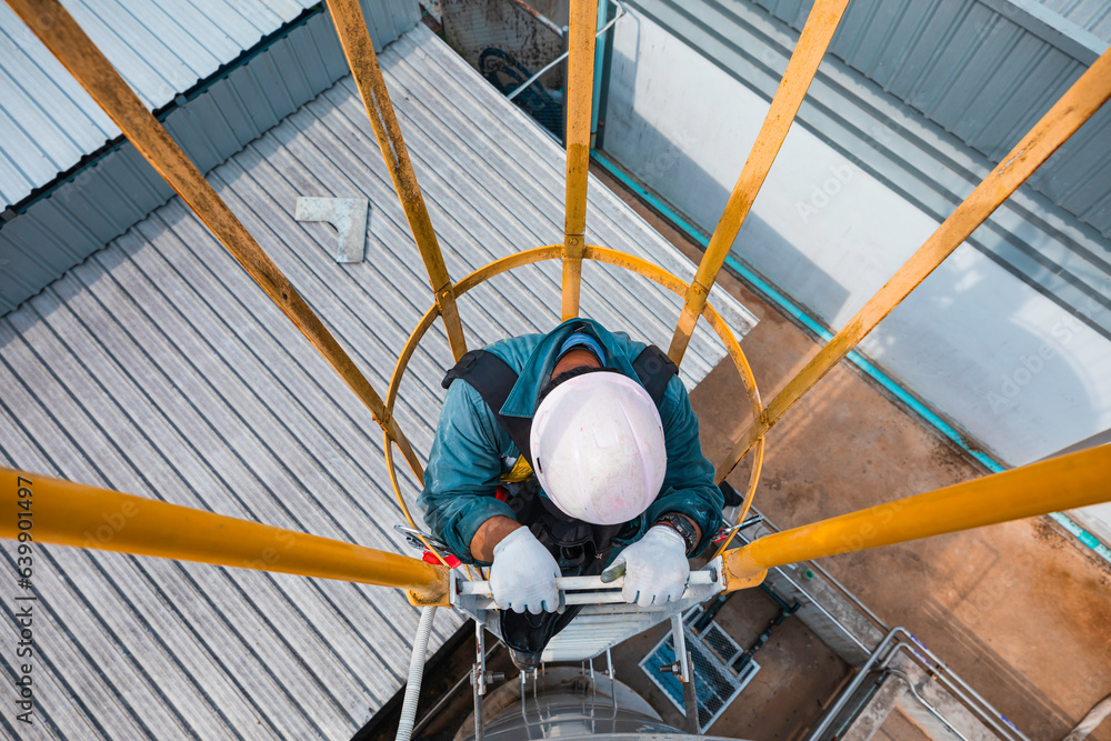 Top view male worker climbs down the ladder inspection stainless tank ...