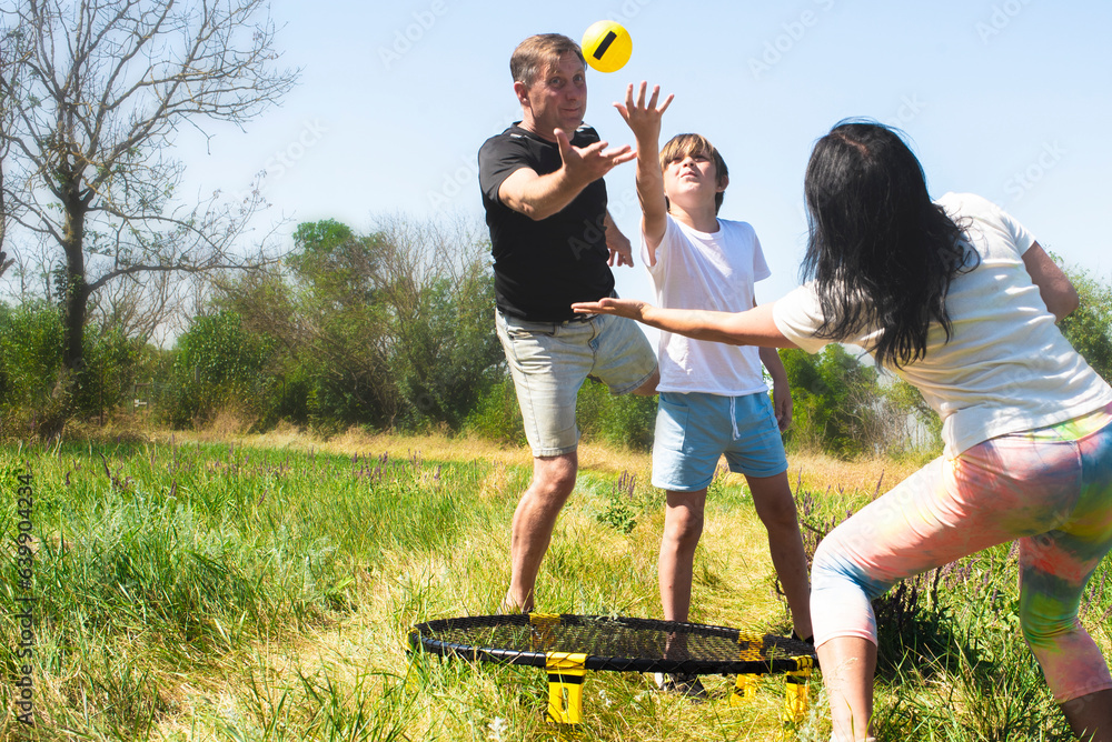 family playing spikeball in nature. parents with children play active ...