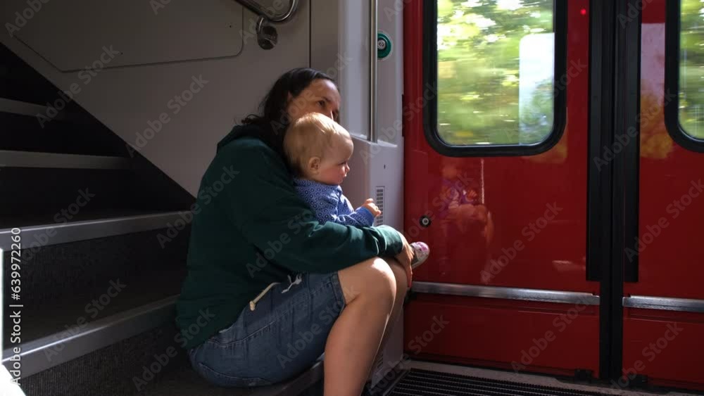 Young mother travelling with cute baby, sitting on steps of Mass Rapid ...