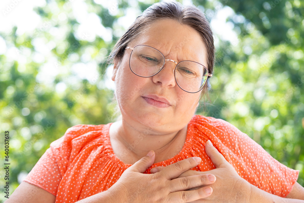 woman 40-45 years old holds on to heart, sudden chest pain, close up ...