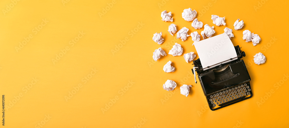 Vintage typewriter with a blank blank sheet and a pile of crumpled ...