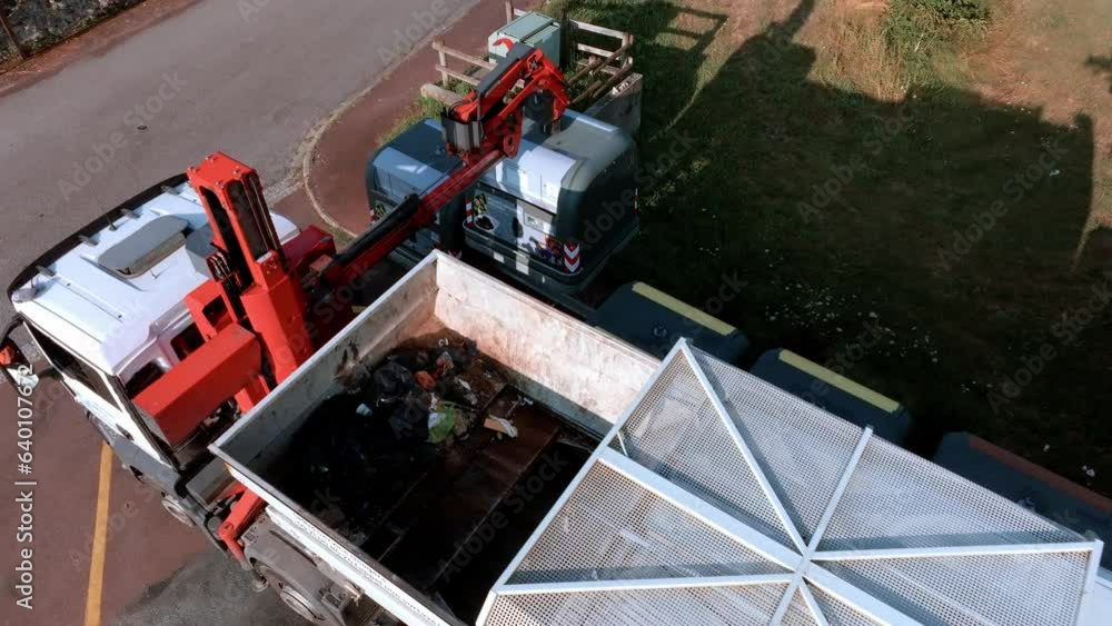 Refuse truck is collecting recycled glass from containers by the ...