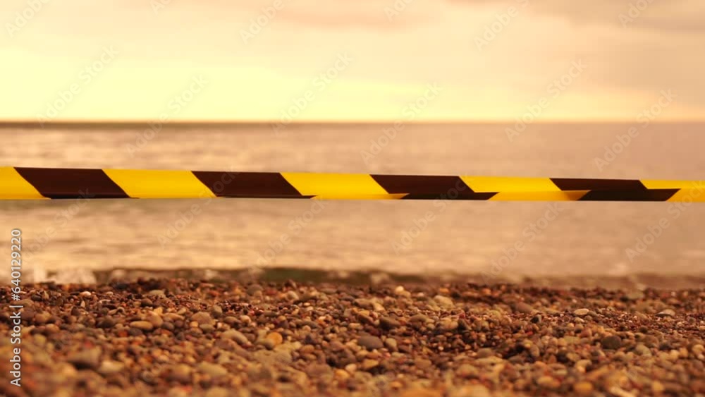 Yellow black warning tape barrier ribbon swinging in the wind across ...