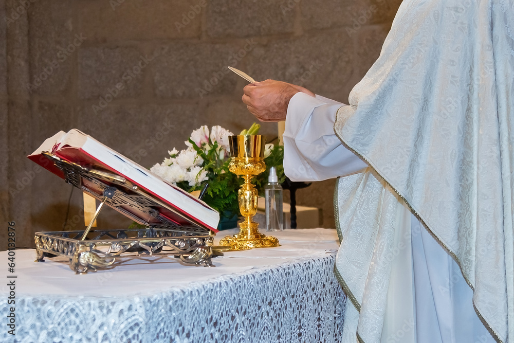 Eucharist ceremony during mass. Catholic ritual. Priest in a white ...
