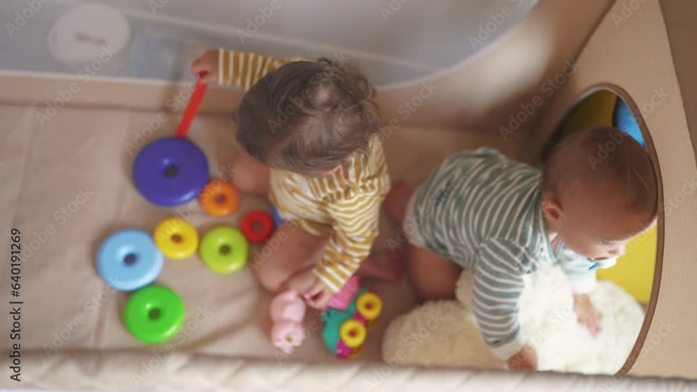Video „a group of children baby twins play pyramid toys in a crib arena ...