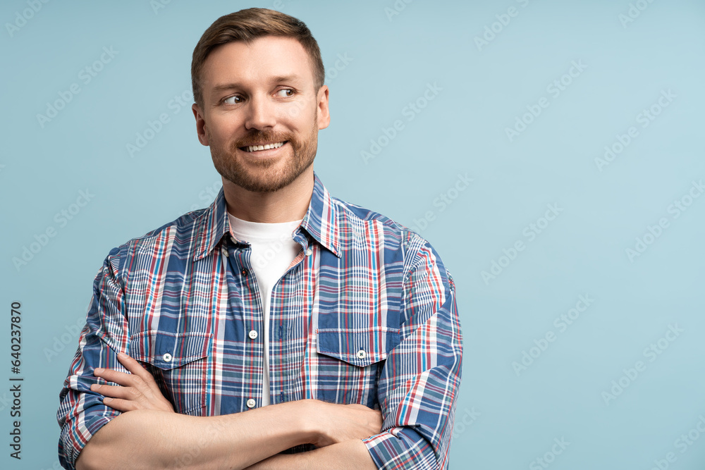 Interested positive guy with confident crossed arms looks to side on ...